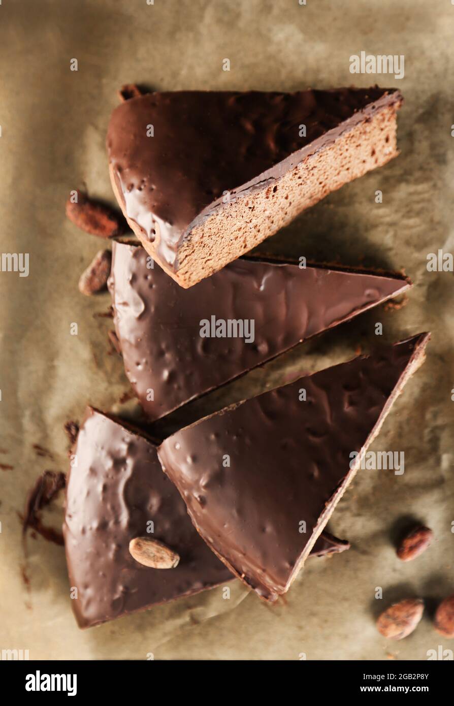 Pieces of frosting chocolate cake on parchment paper Stock Photo - Alamy
