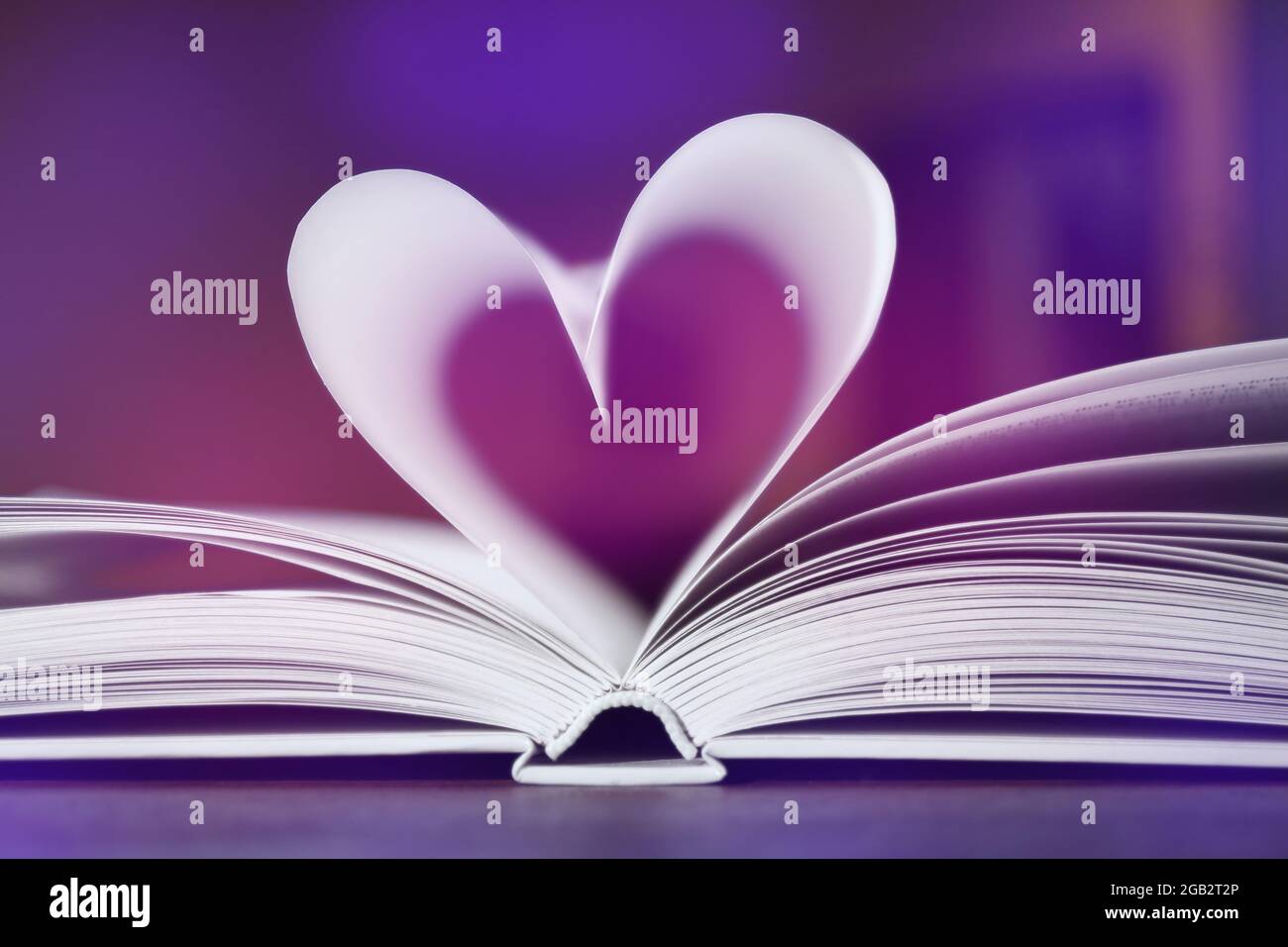 Heart from book pages on dark blurred background Stock Photo - Alamy