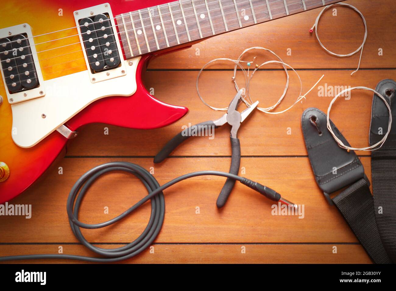 Electric guitar with pliers and strings on wooden background Stock ...