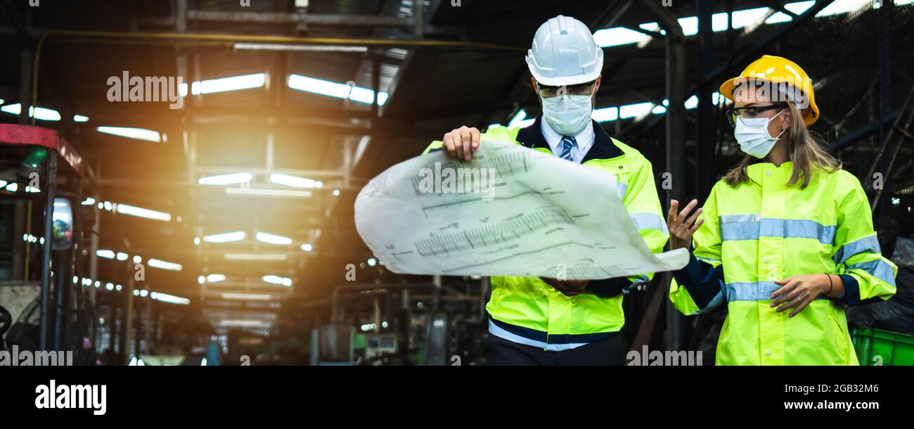 Engineer team wearing face mask, reflective vest and helmet check and ...