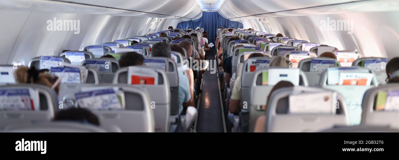 Passengers sitting in seats of plane back view Stock Photo - Alamy