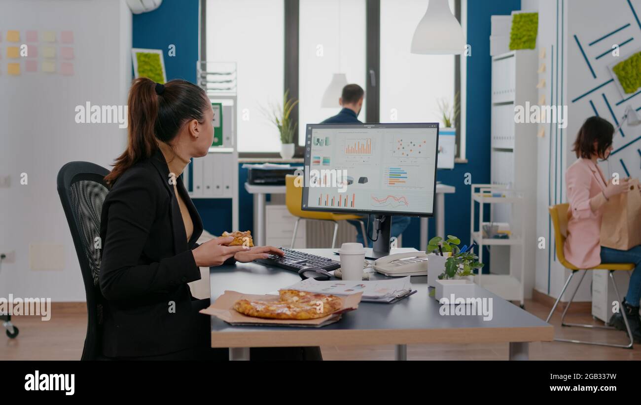Businesswoman enjoying food meal order in company office during takeout ...