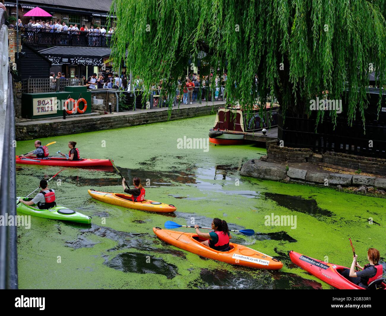 A group of kayakers heading under a bridge along the Regent's Canal at ...