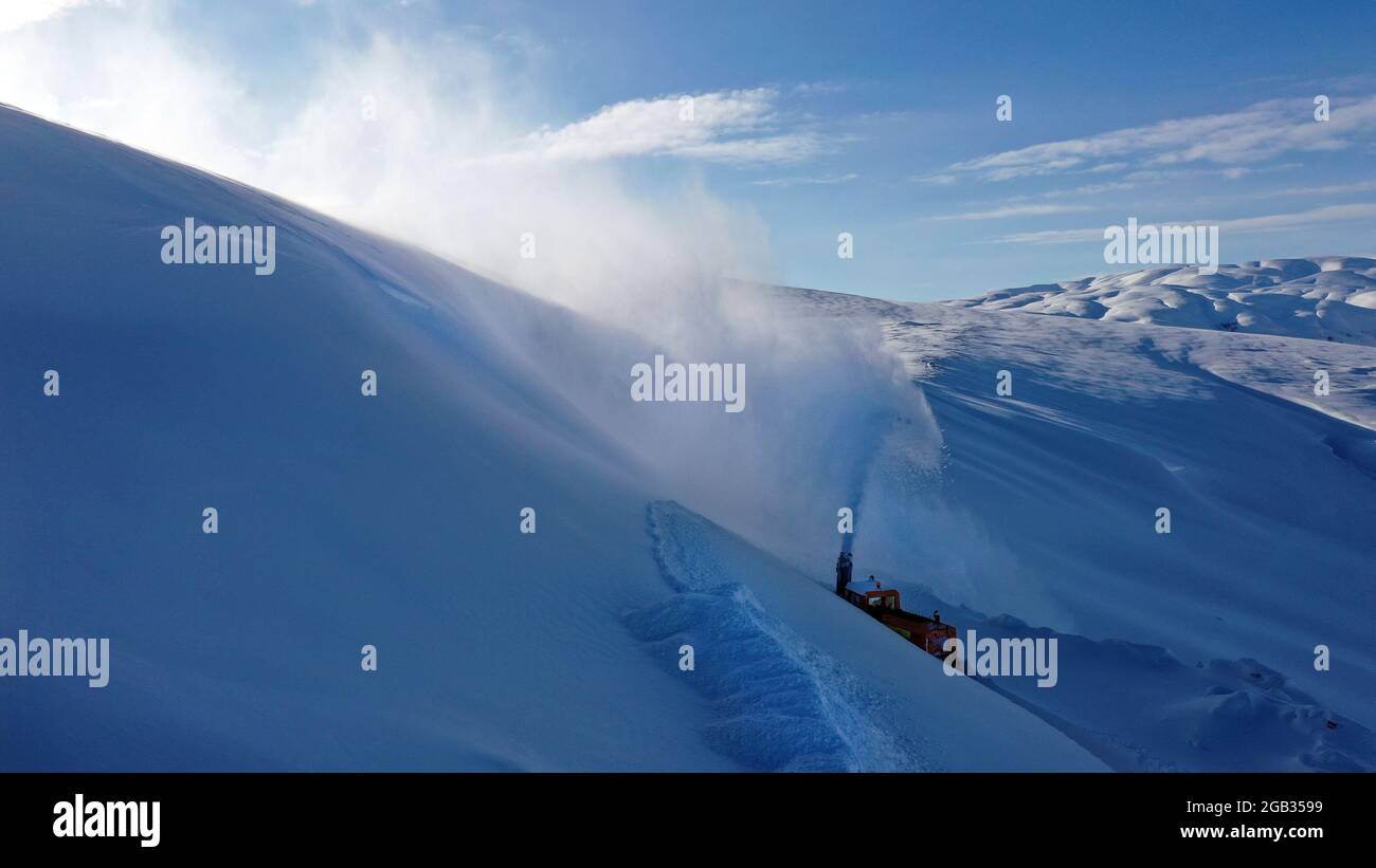 A snow blower car clears snow in on the mountain from the road on a ...