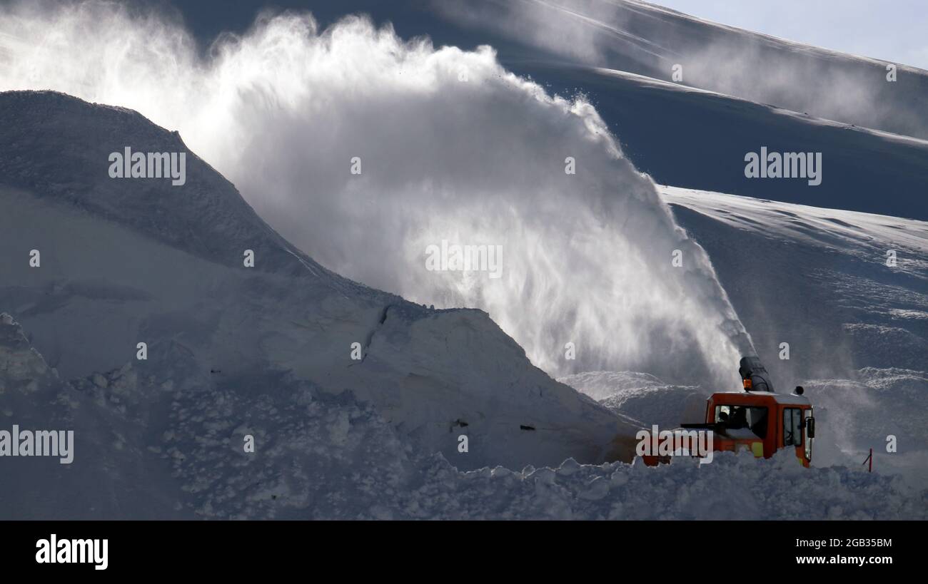 A snow blower car clears snow in on the mountain from the road on a ...