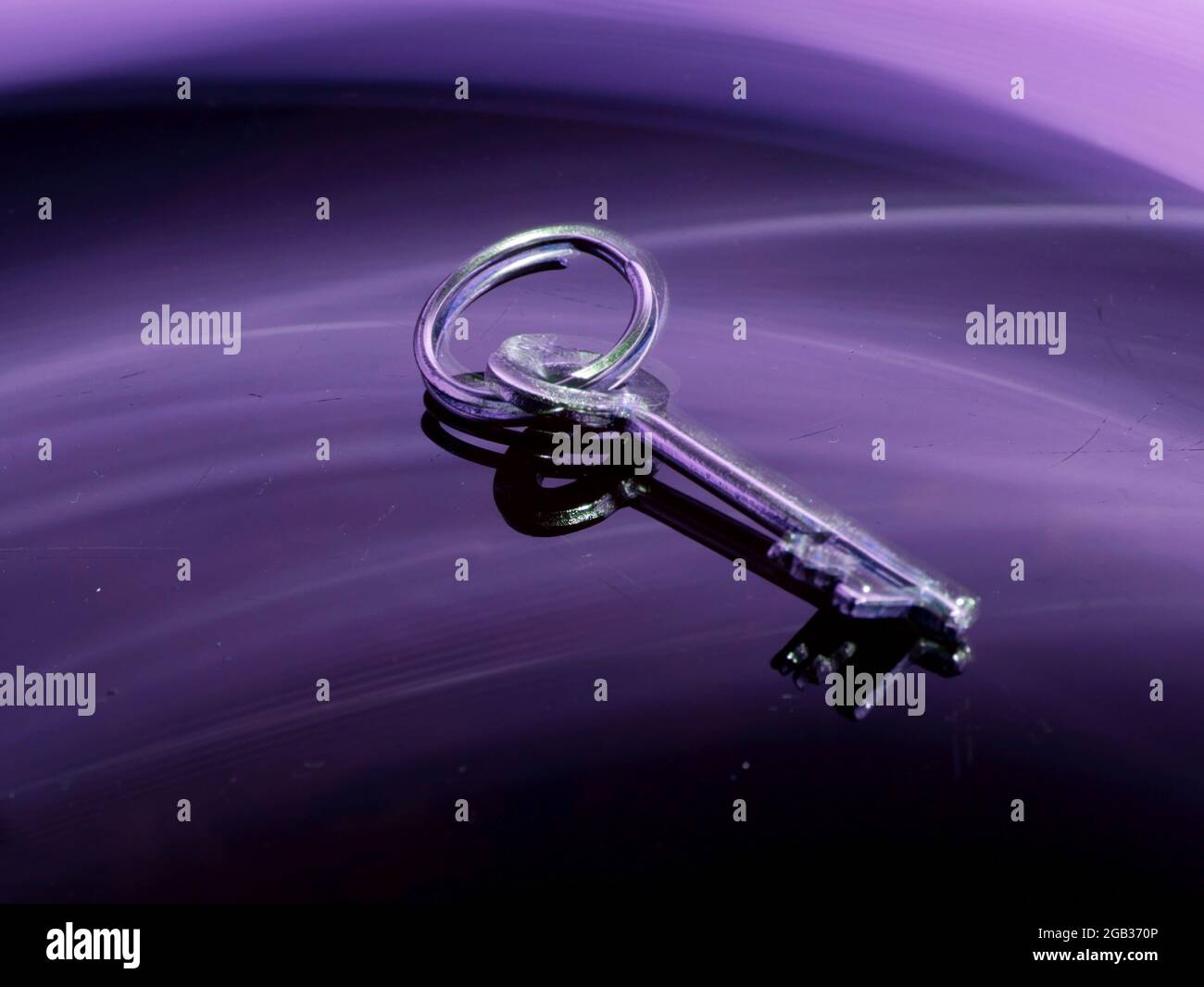 Single metal key presented with bluish light effect background ...