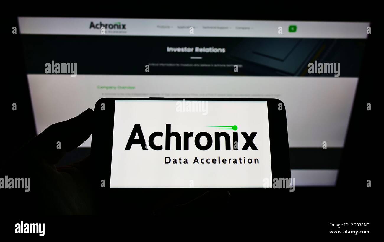 Person holding cellphone with logo of US company Achronix Semiconductor Corp. on screen in front ...
