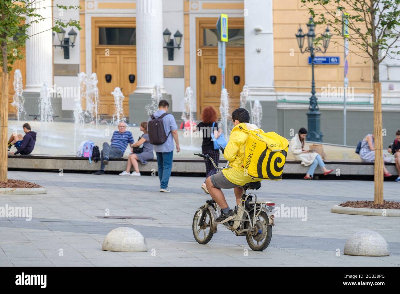 Moscow. Russia. August 1, 2021. A food delivery man with a yellow ...