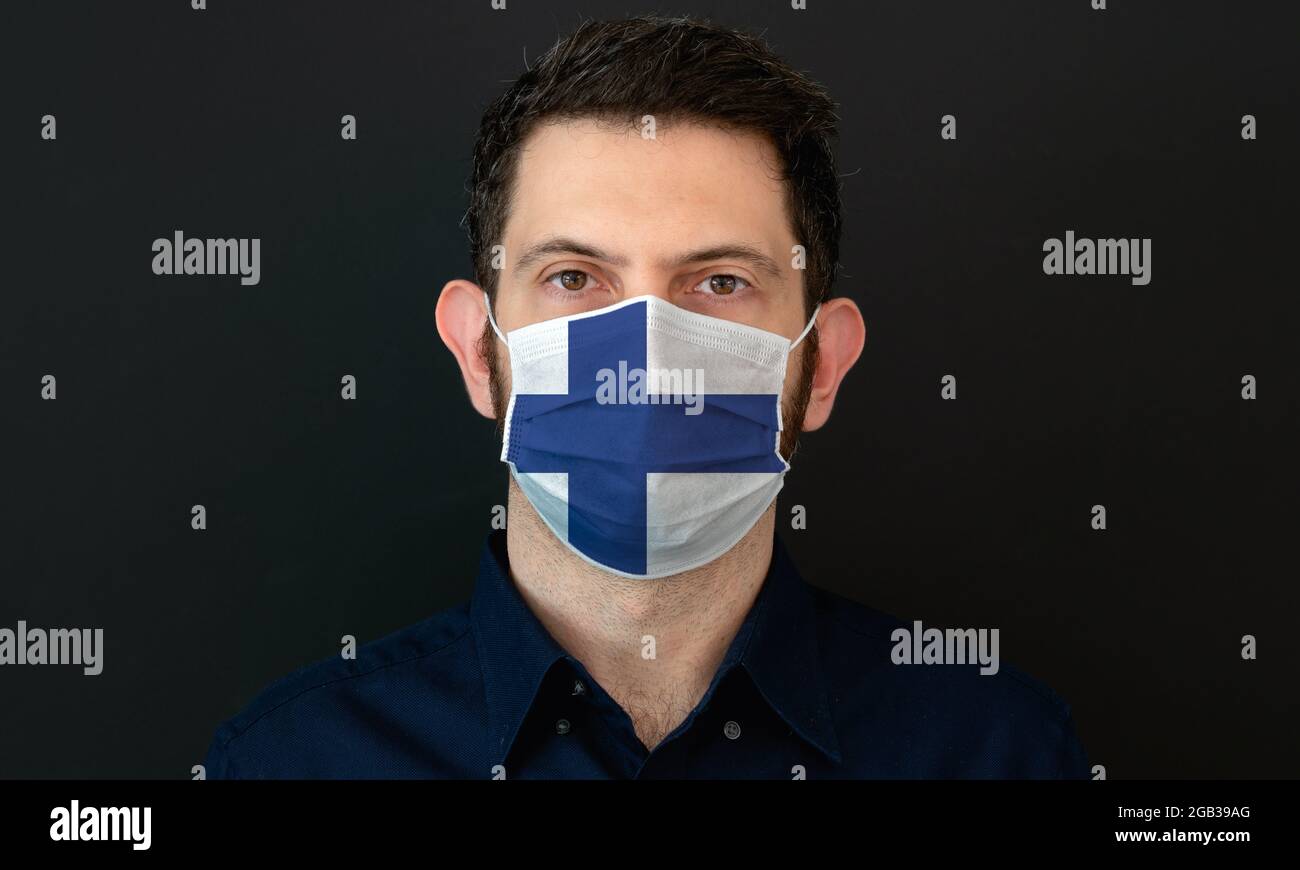 Man wearing Finnish flag protective medical face mask. He looks worried ...