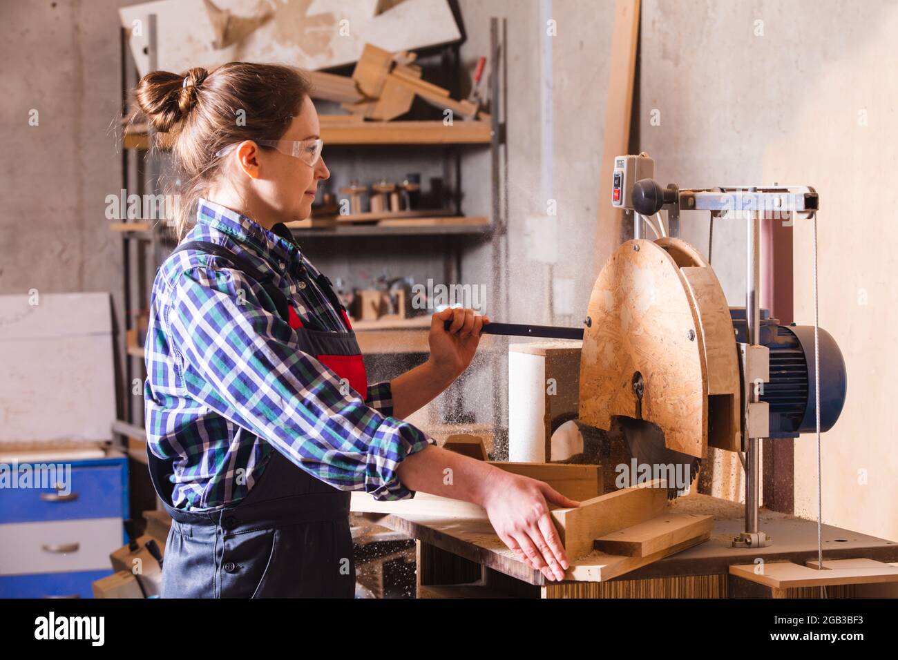 Female employee of woodworking plant operating circular saw Stock Photo ...