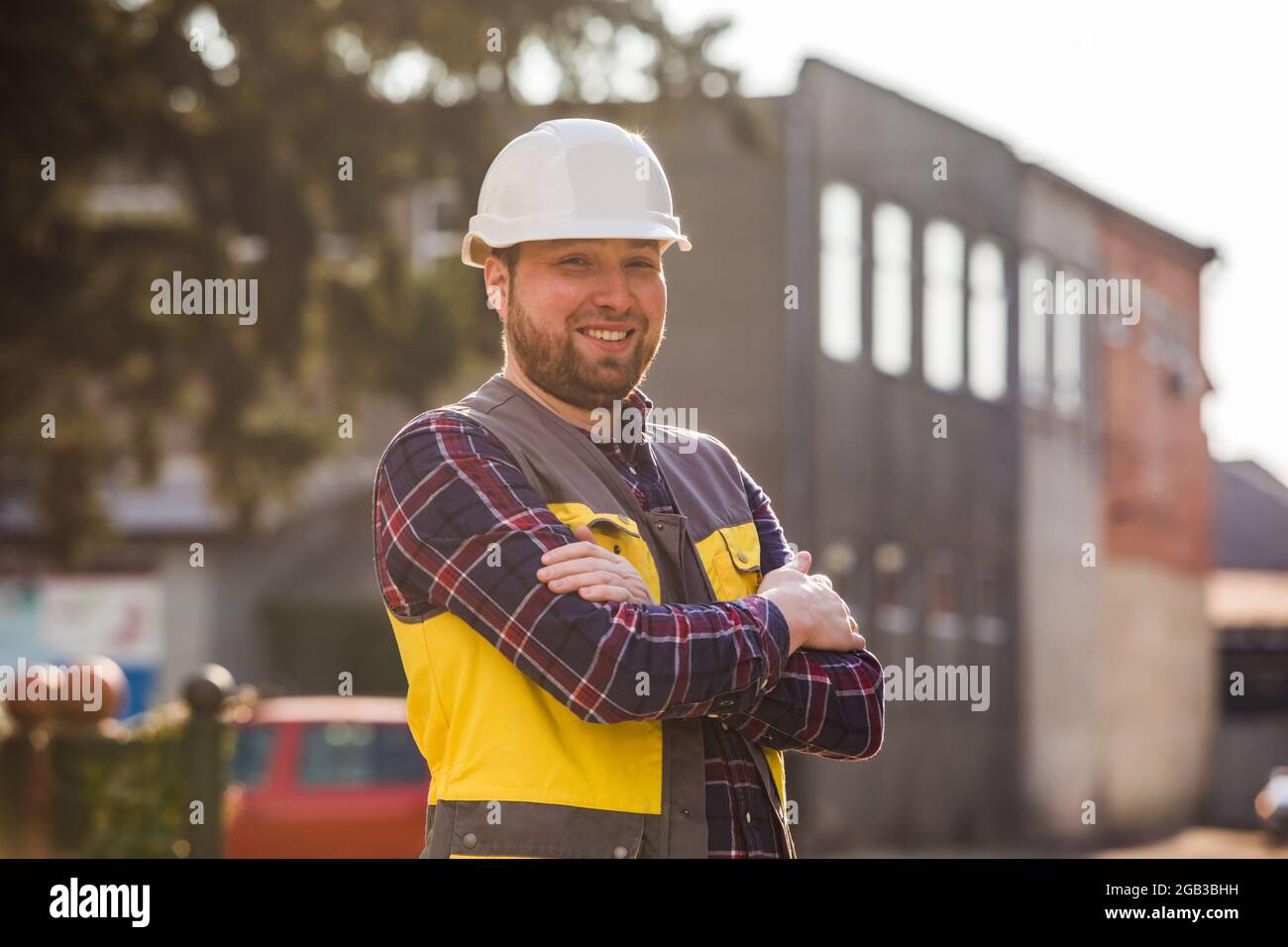 Factory worker posing in front of workshop Stock Photo - Alamy