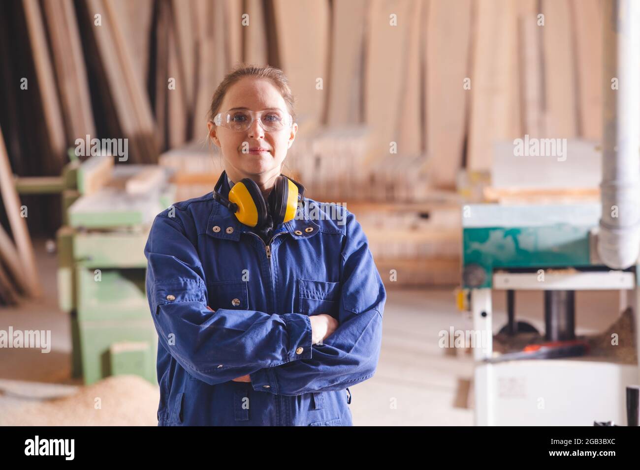 Cheerful female production operator in blue coverall Stock Photo - Alamy