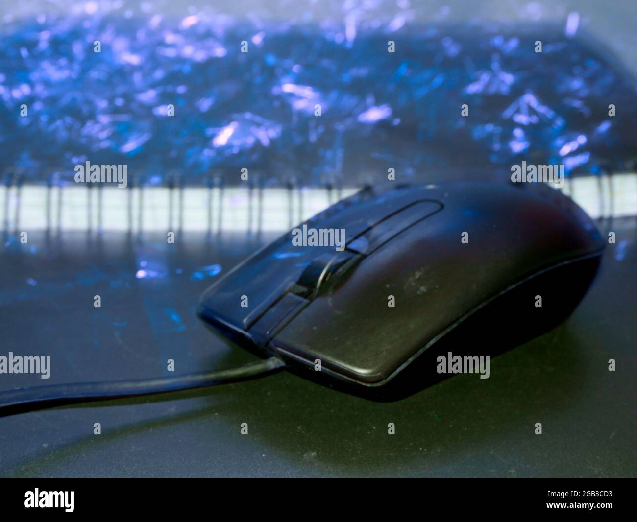 Black color computer mouse displayed with light rays effect on dark ...