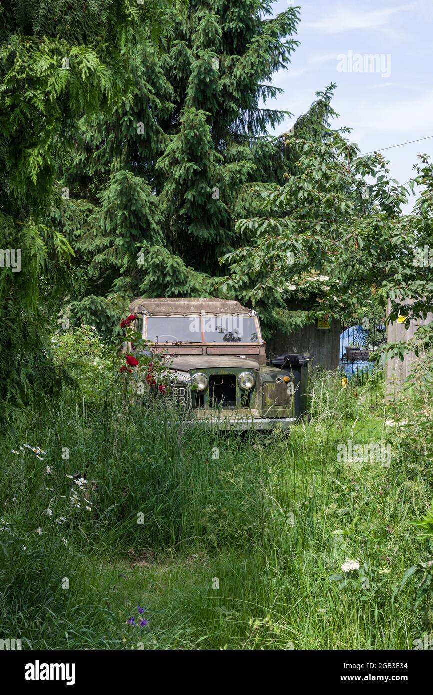 Broken down Land Rover in an overgrown front garden in the village of ...