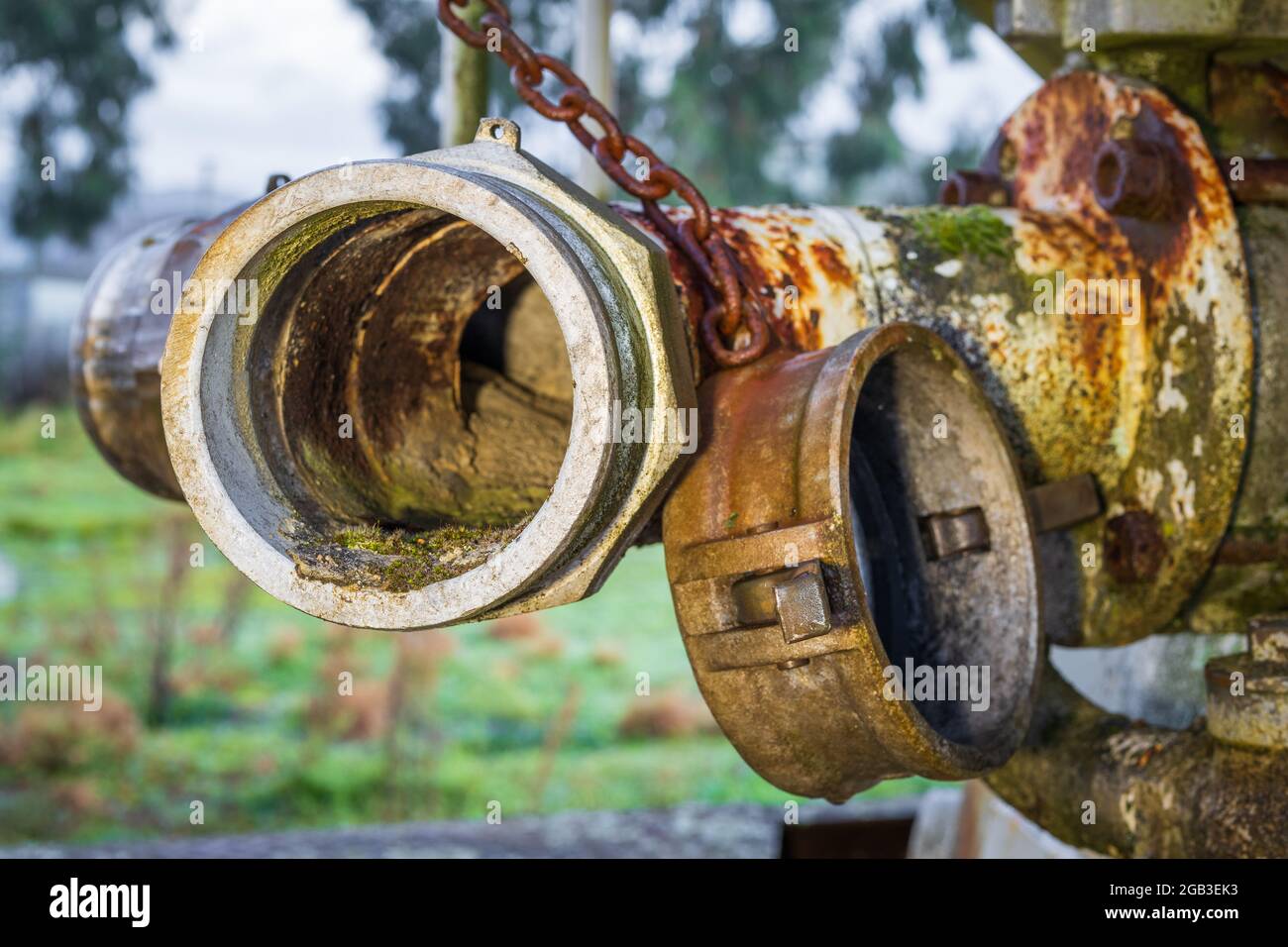 Old pipe outlet with it's cap too. Looking very old with rust and moss ...