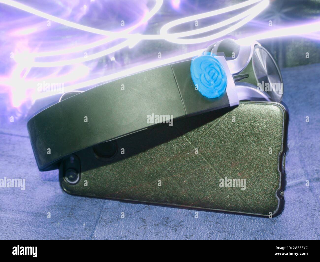 Mobile phone displayed with head phone setup on light rays background ...