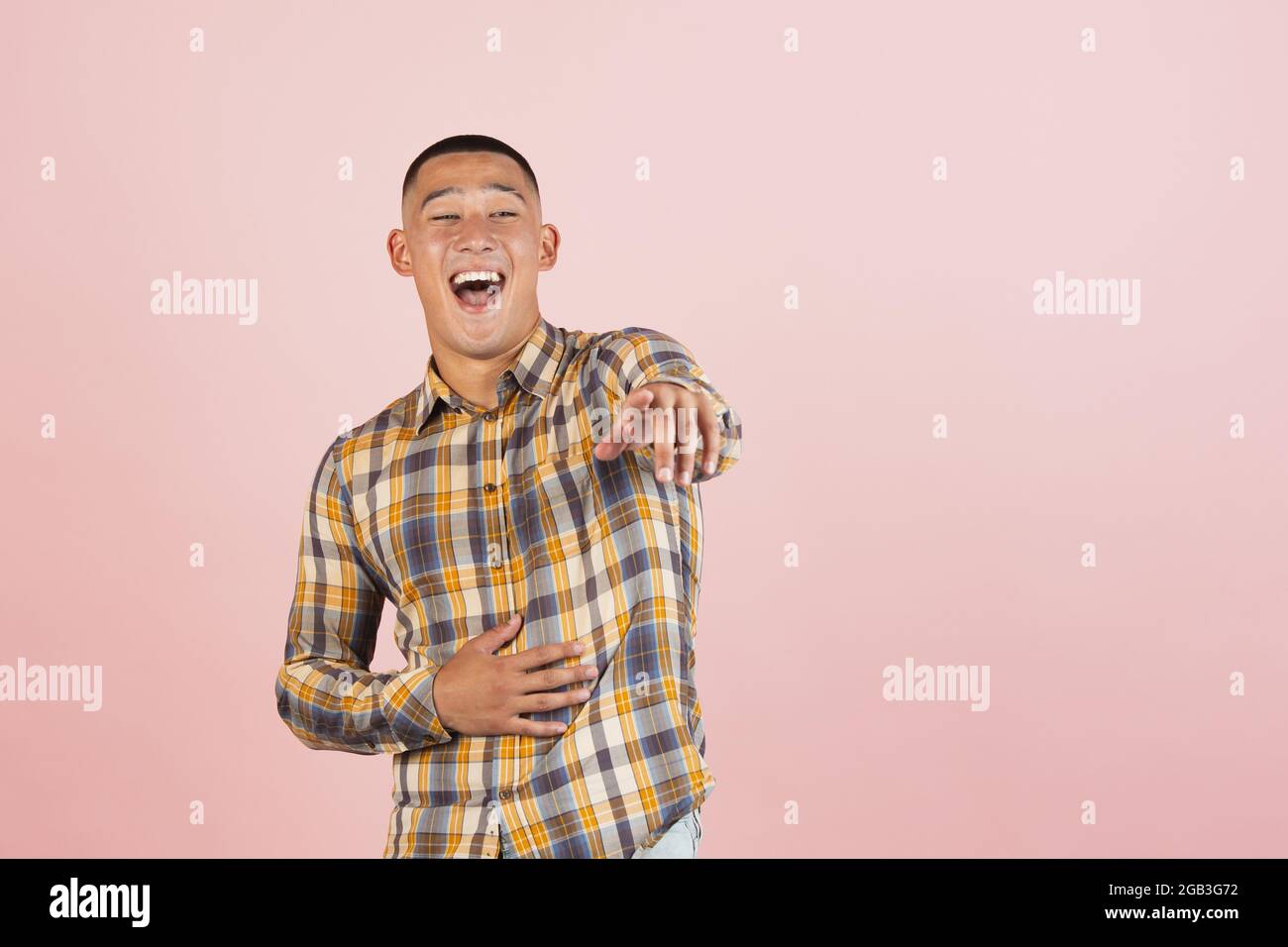 Portrait of young smiling handsome asian man in a plaid shirt isolated ...