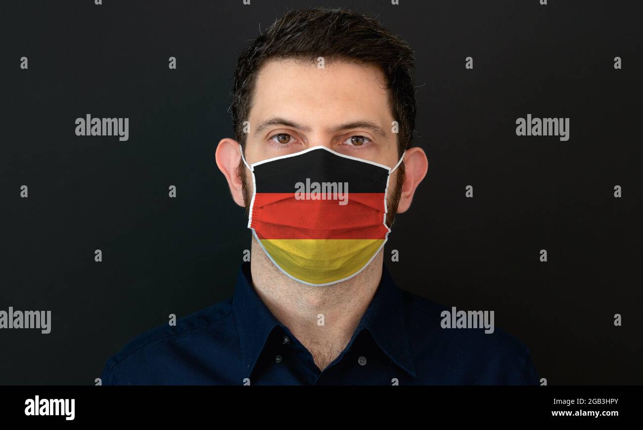 Man wearing German flag protective medical face mask. He looks worried ...