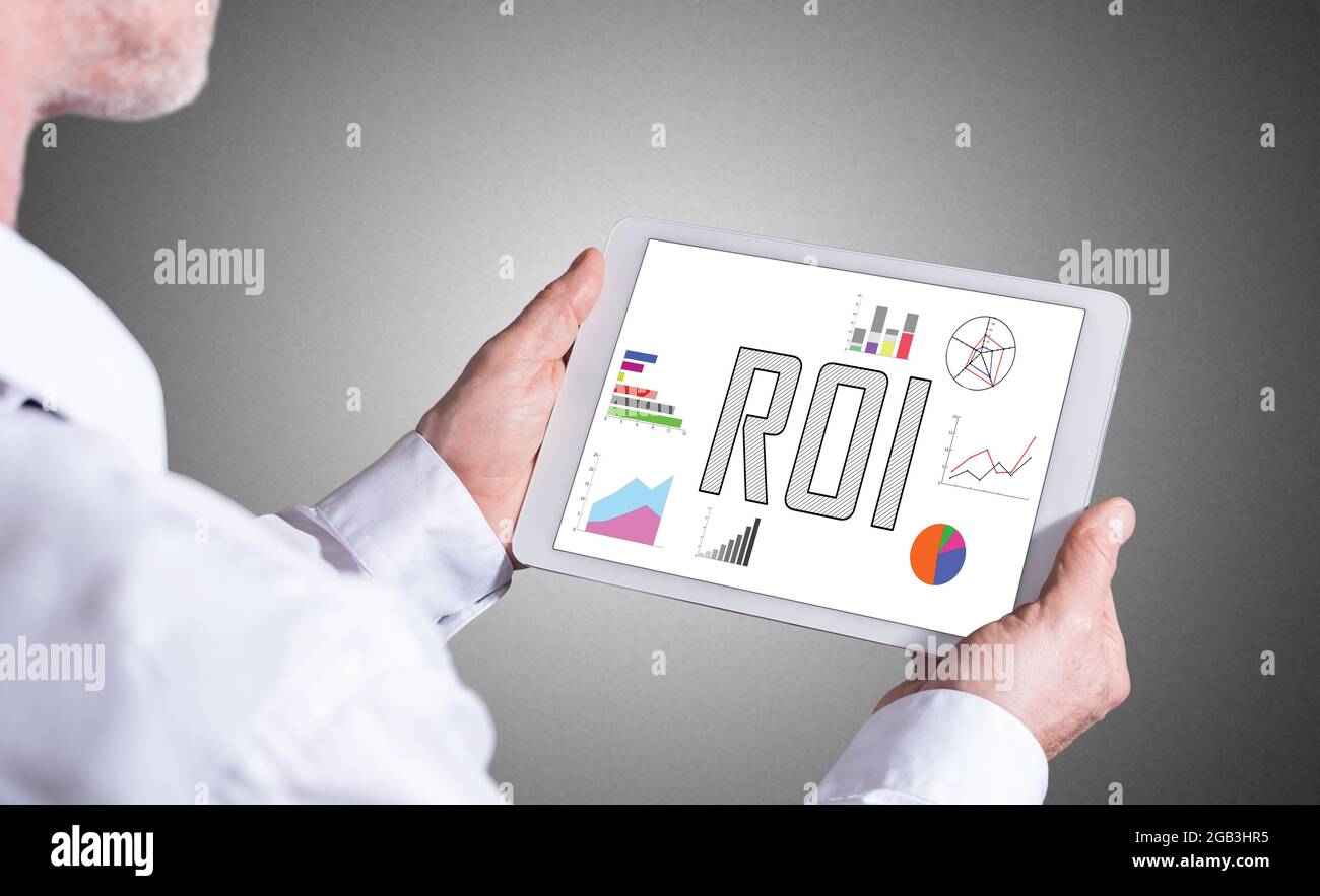 Man holding a tablet showing roi concept Stock Photo - Alamy