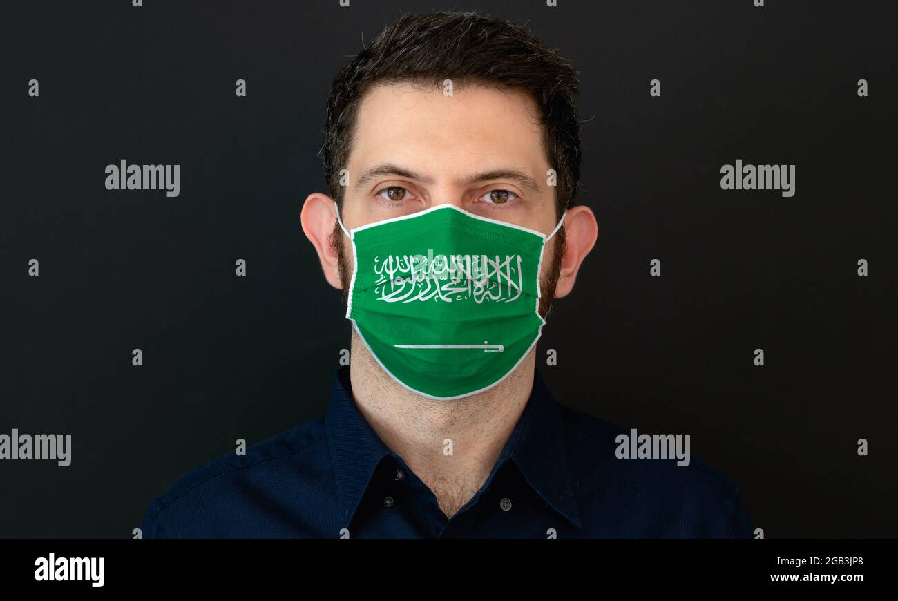 Man wearing Saudi Arabian flag protective medical face mask. He looks ...