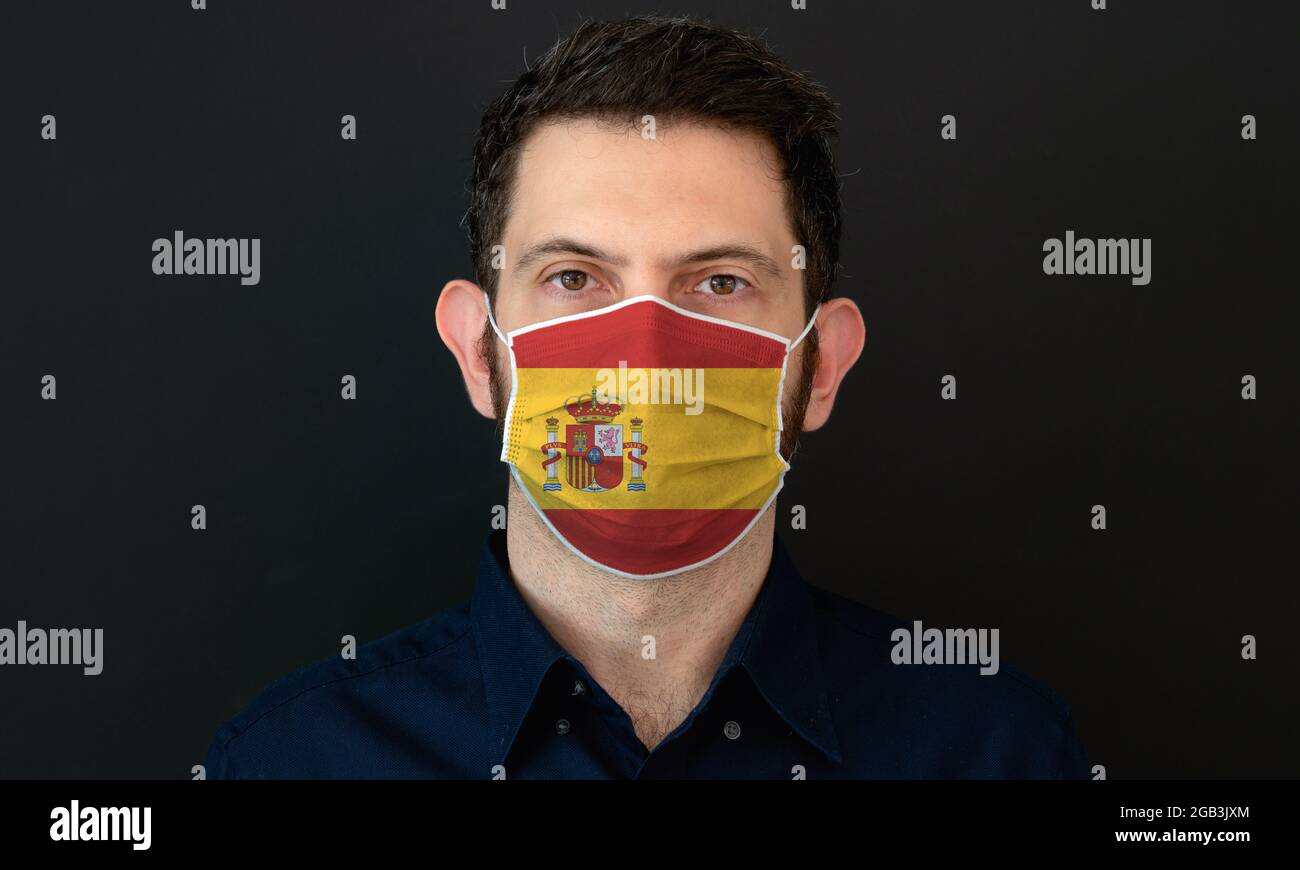 Man wearing Spanish flag protective medical face mask. He looks worried ...