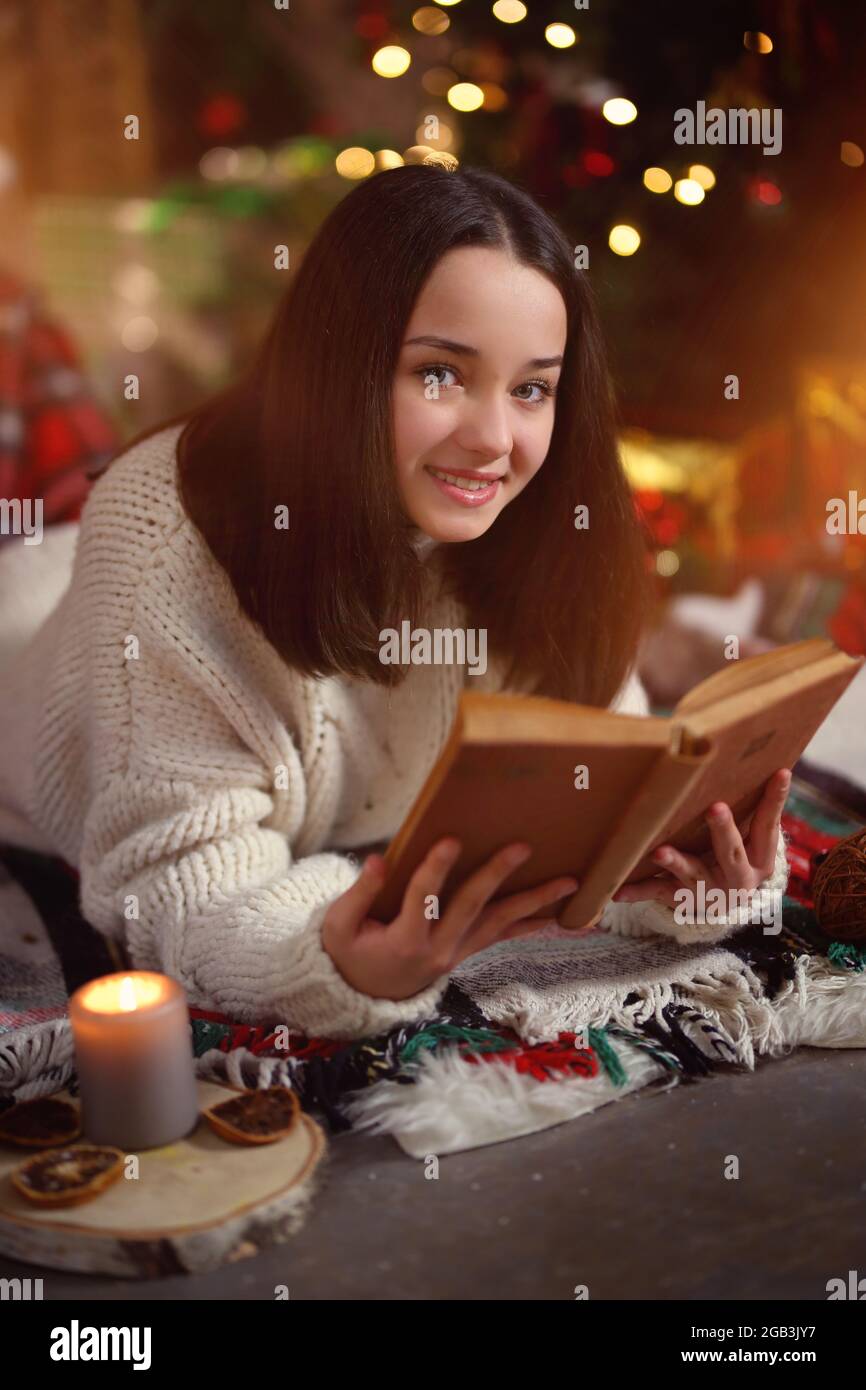 young girl reading a book on a winter evening Stock Photo - Alamy