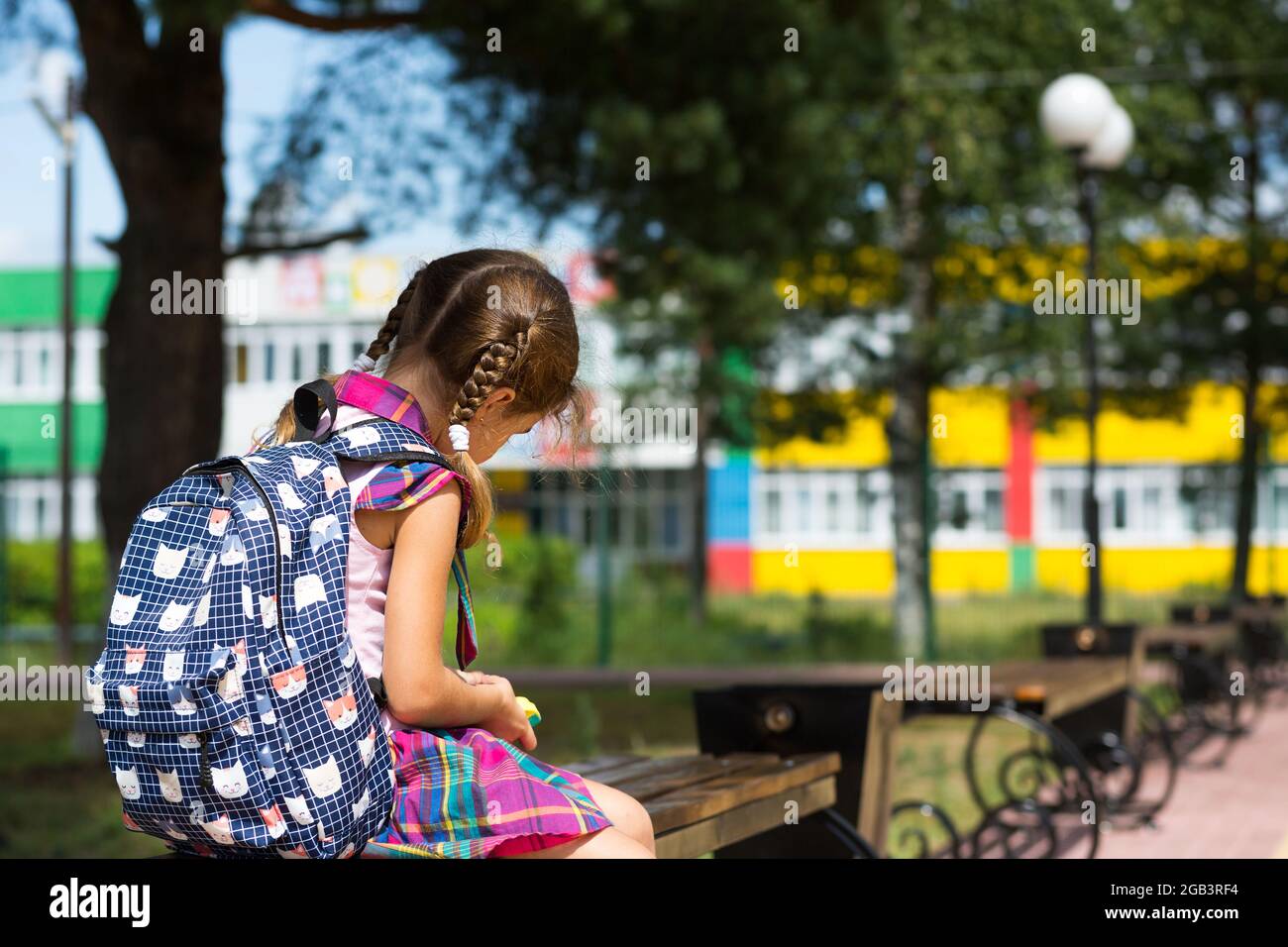 Sad, upset girl near the school with a backpack. Fatigue from classes ...