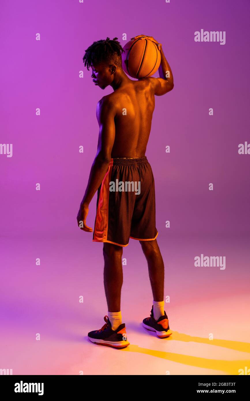 Young african man, basketball player posing with ball isolated over ...