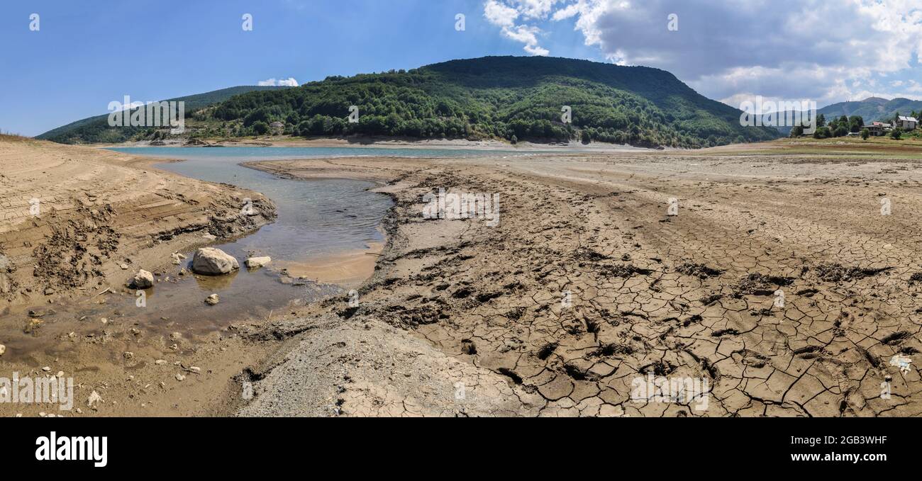 Panorama from the shore of a lake where much of the water has dried up ...
