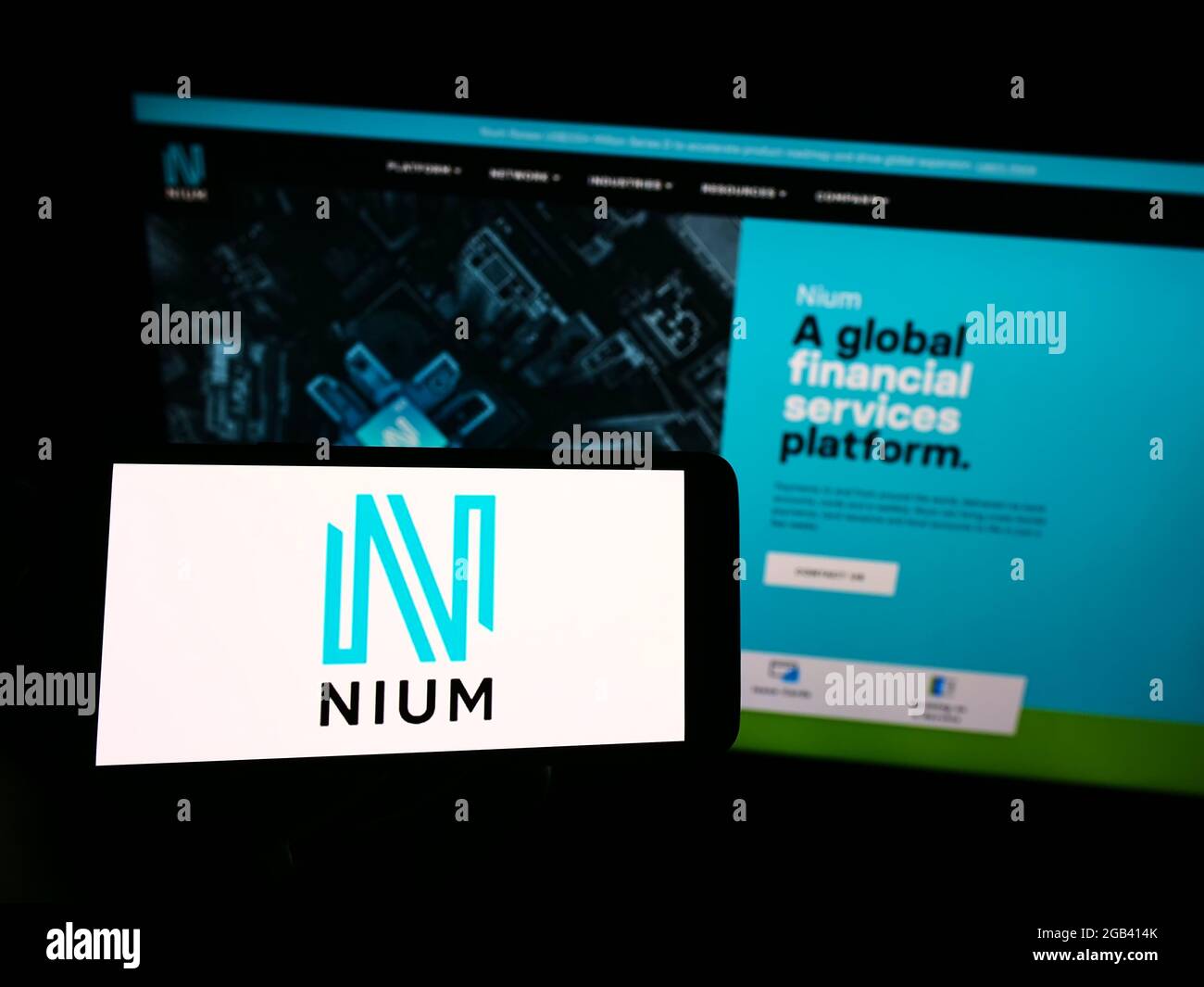 Person holding mobile phone with logo of Singaporean payment company ...