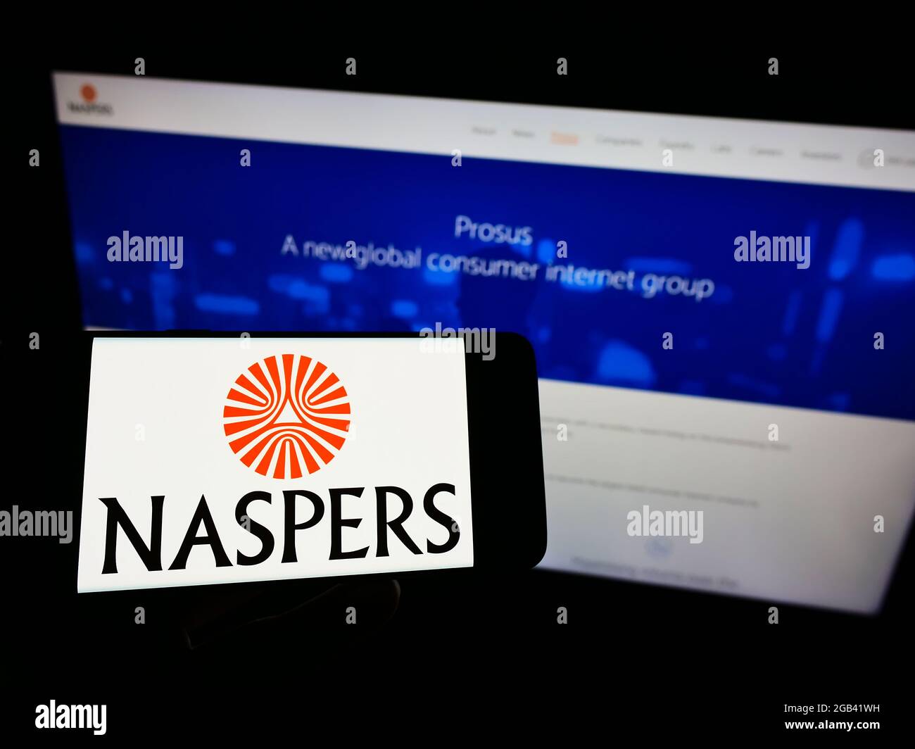 Person holding cellphone with logo of South African conglomerate ...