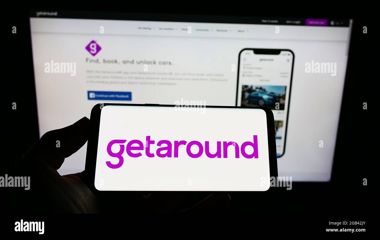 Person holding cellphone with logo of American car sharing company ...