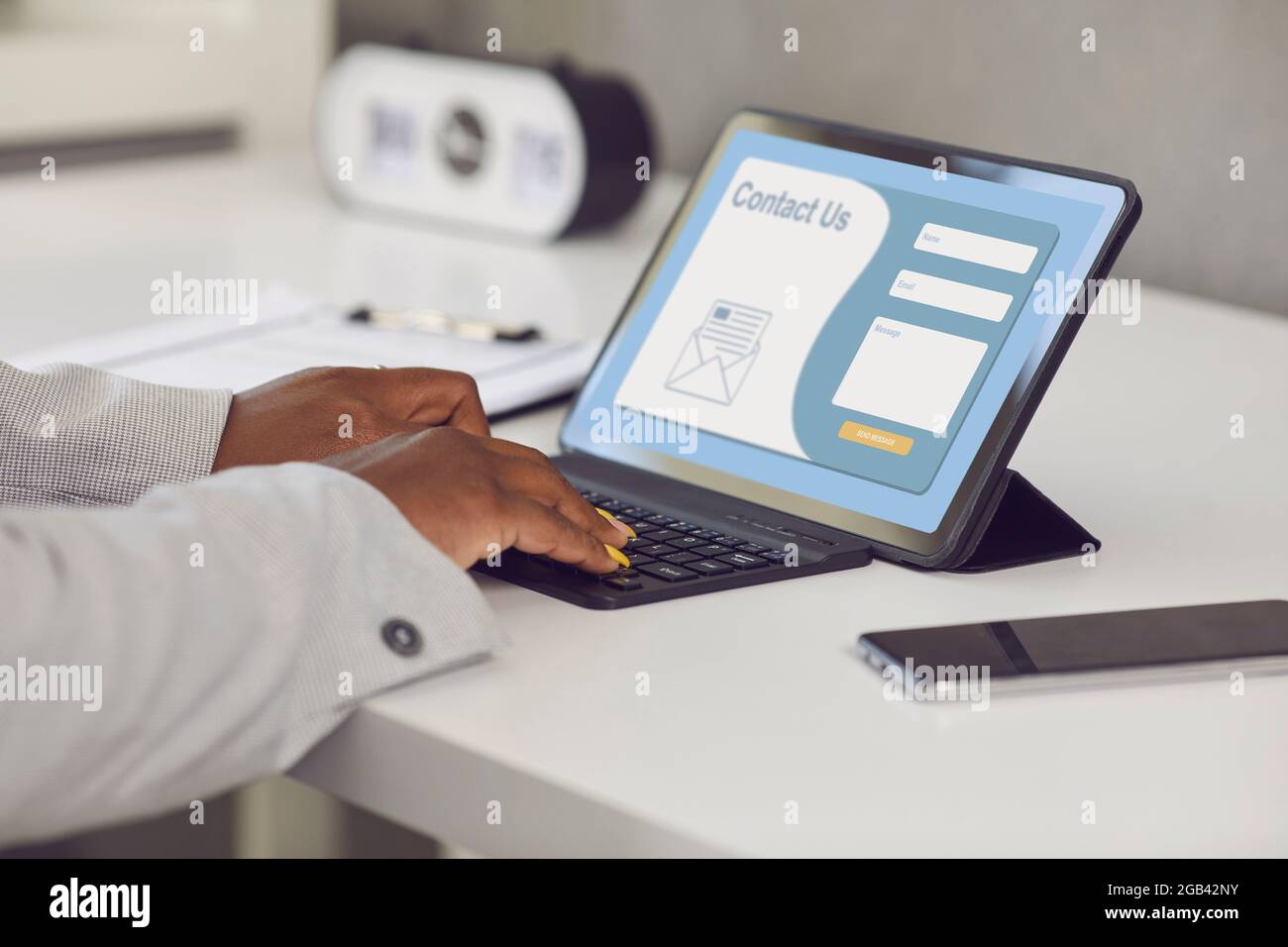 Customer using tablet and writing email in Contact Us form on landing ...