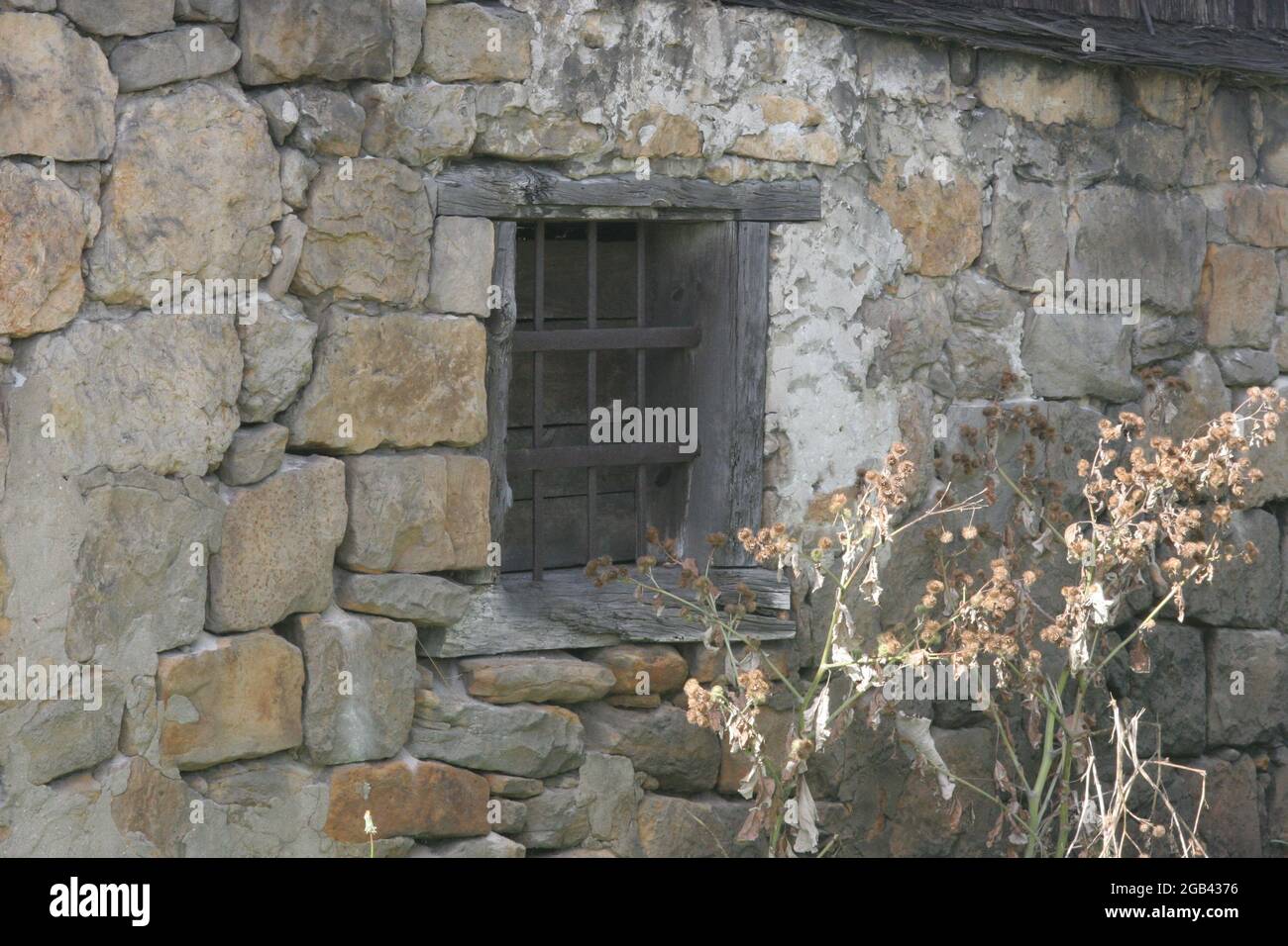 Old window with grille and stone wall Stock Photo - Alamy