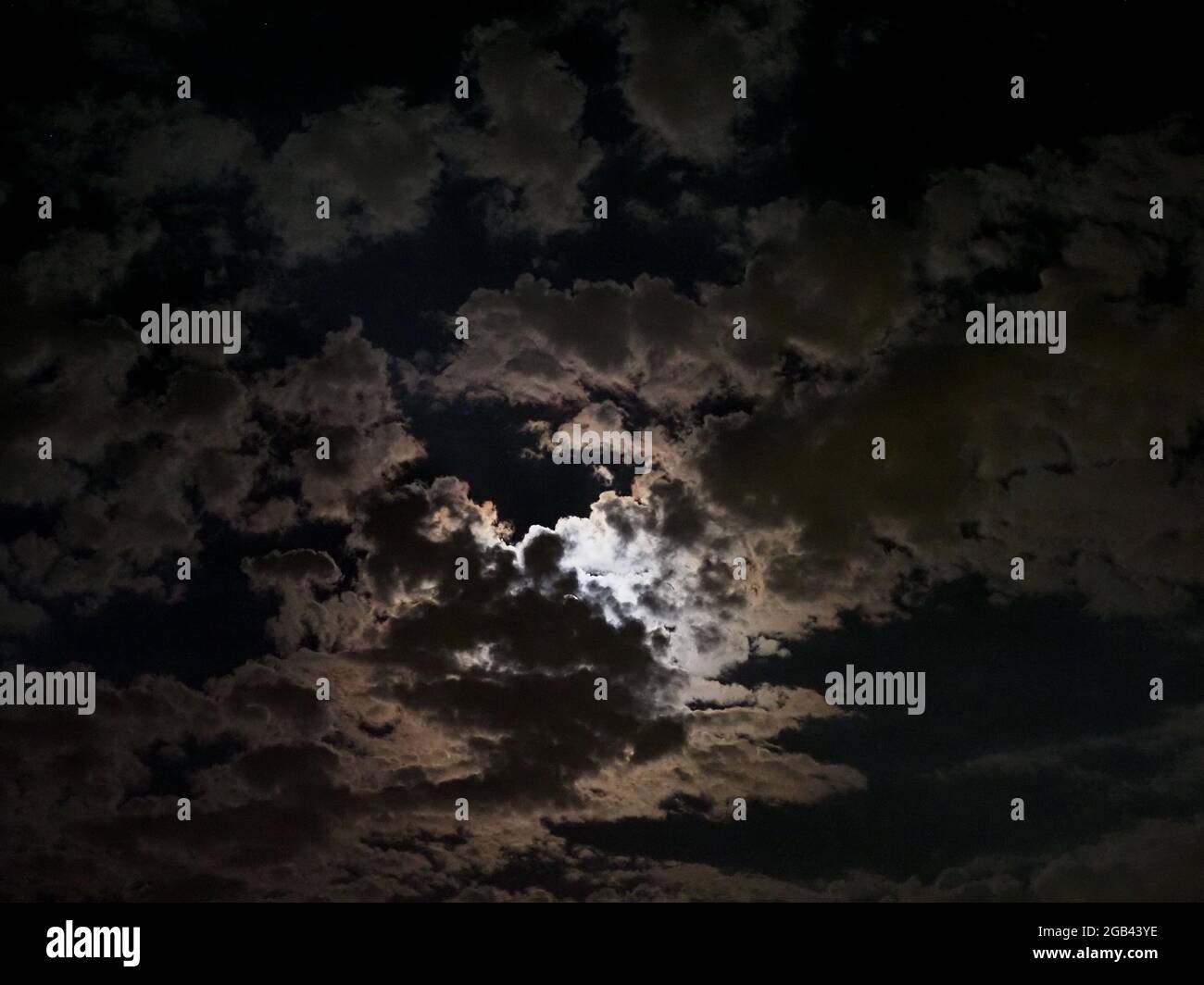 moon light behind dark clouds in stormy weather Stock Photo - Alamy