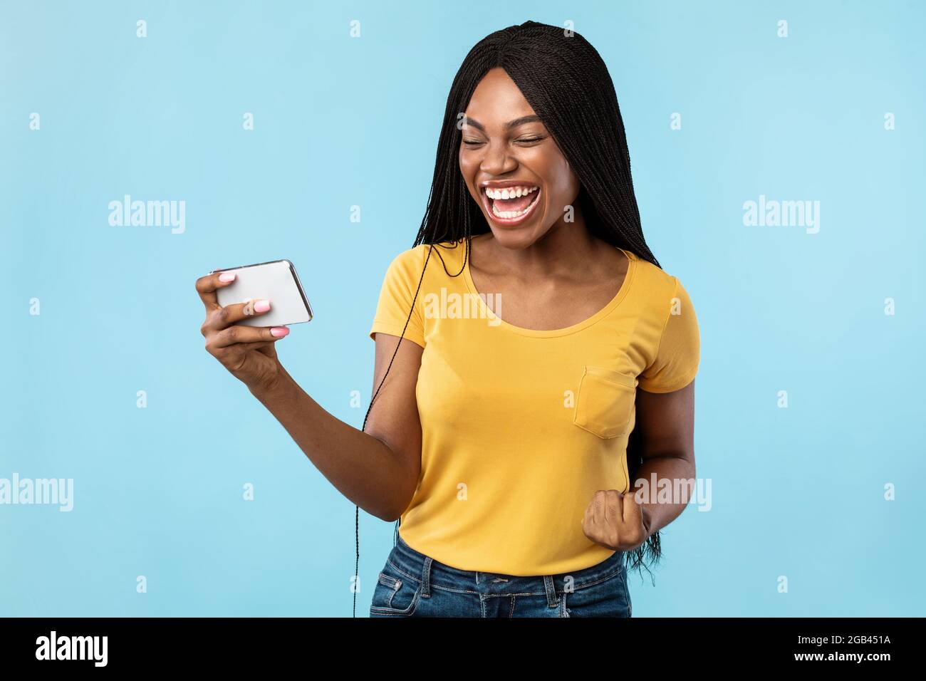 African American Female With Smartphone Gesturing Yes Over Blue ...