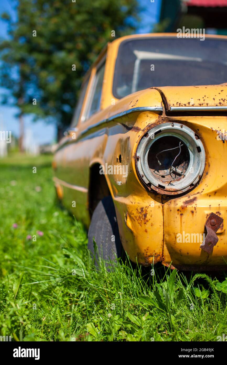 Old yellow wrecked car in vintage style. Abandoned rusty yellow car ...