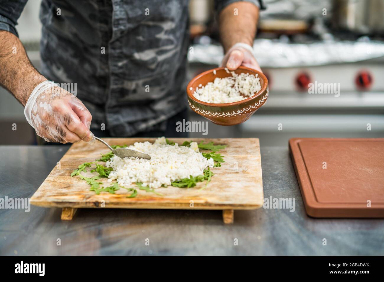 Professional cook is serving meal in restaurant's kitchen Stock Photo ...