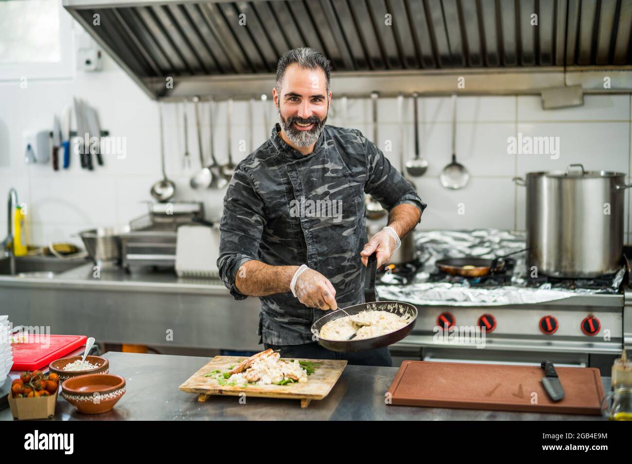 Professional cook is serving meal in restaurant's kitchen Stock Photo ...