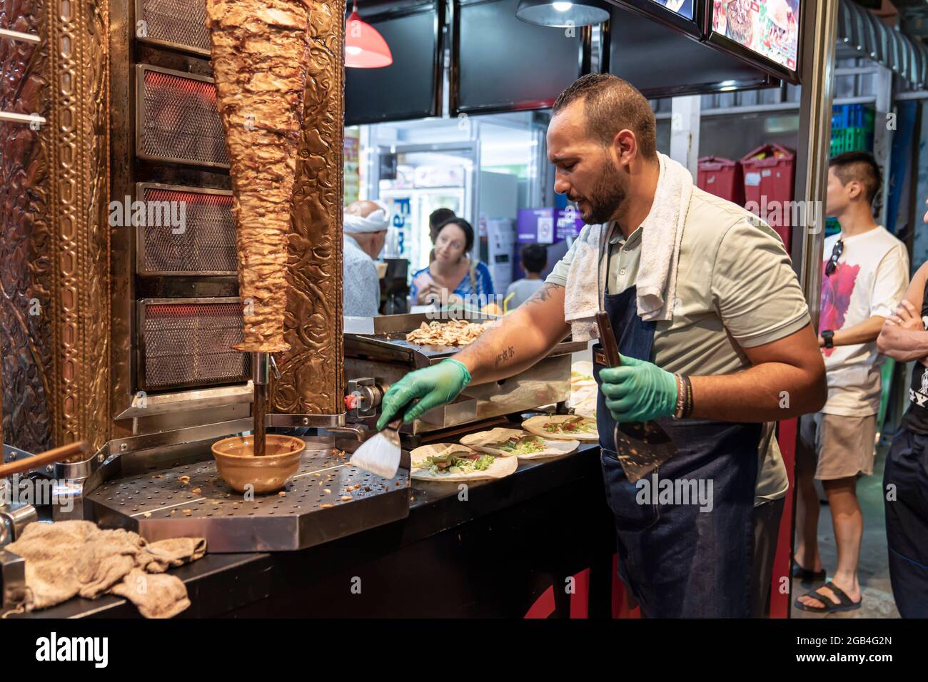 an adult male chef with a stylish hairstyle and beard is preparing a ...
