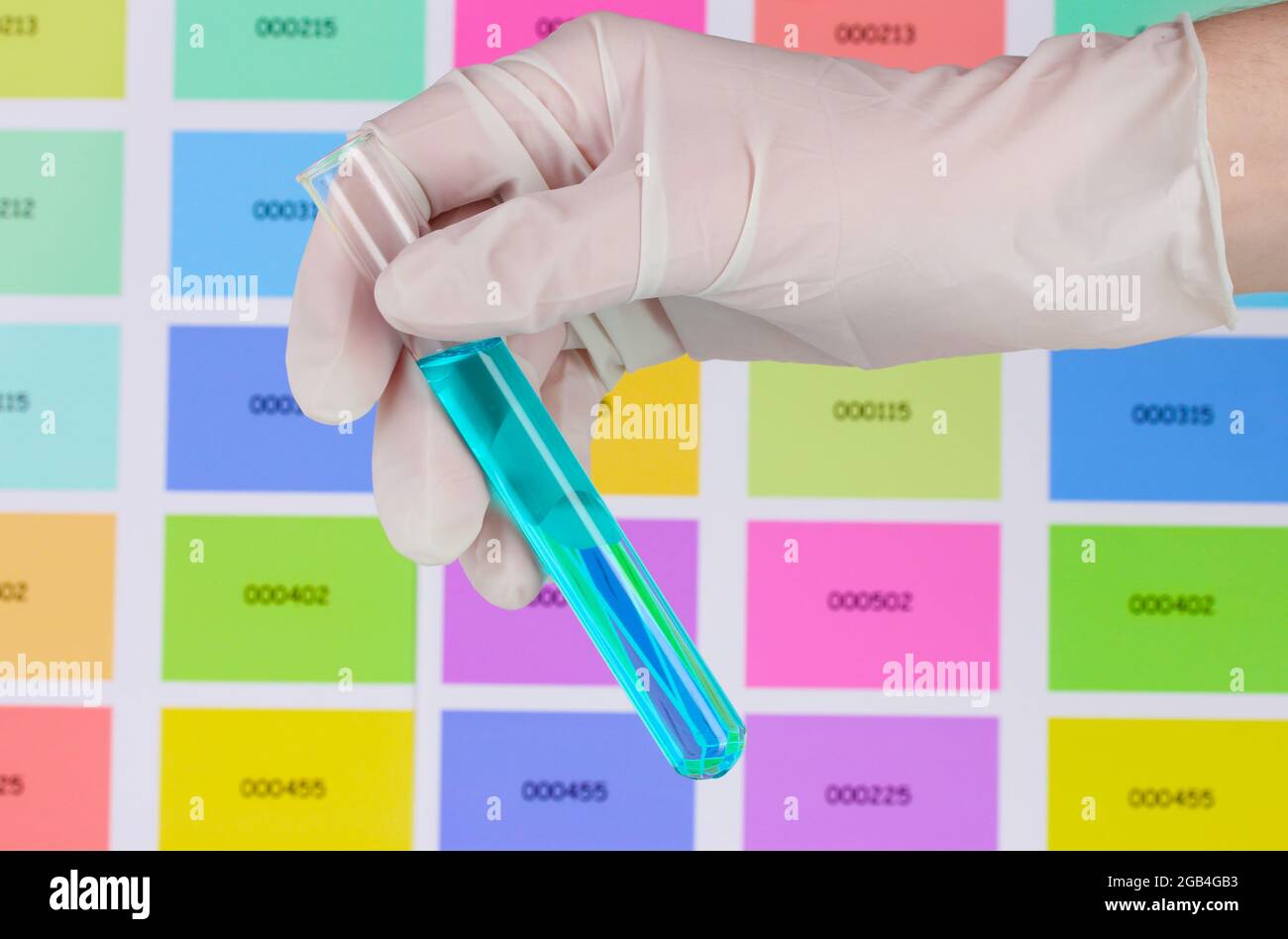 Tube with blue liquid in hand on color samples background Stock Photo ...