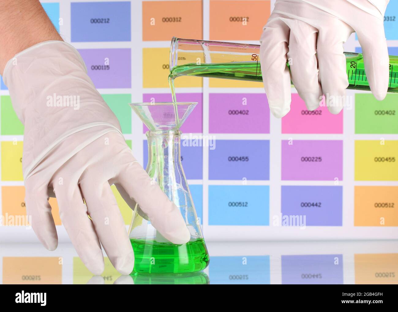 Laboratory flask and tube with green liquid in scientist's hands on ...