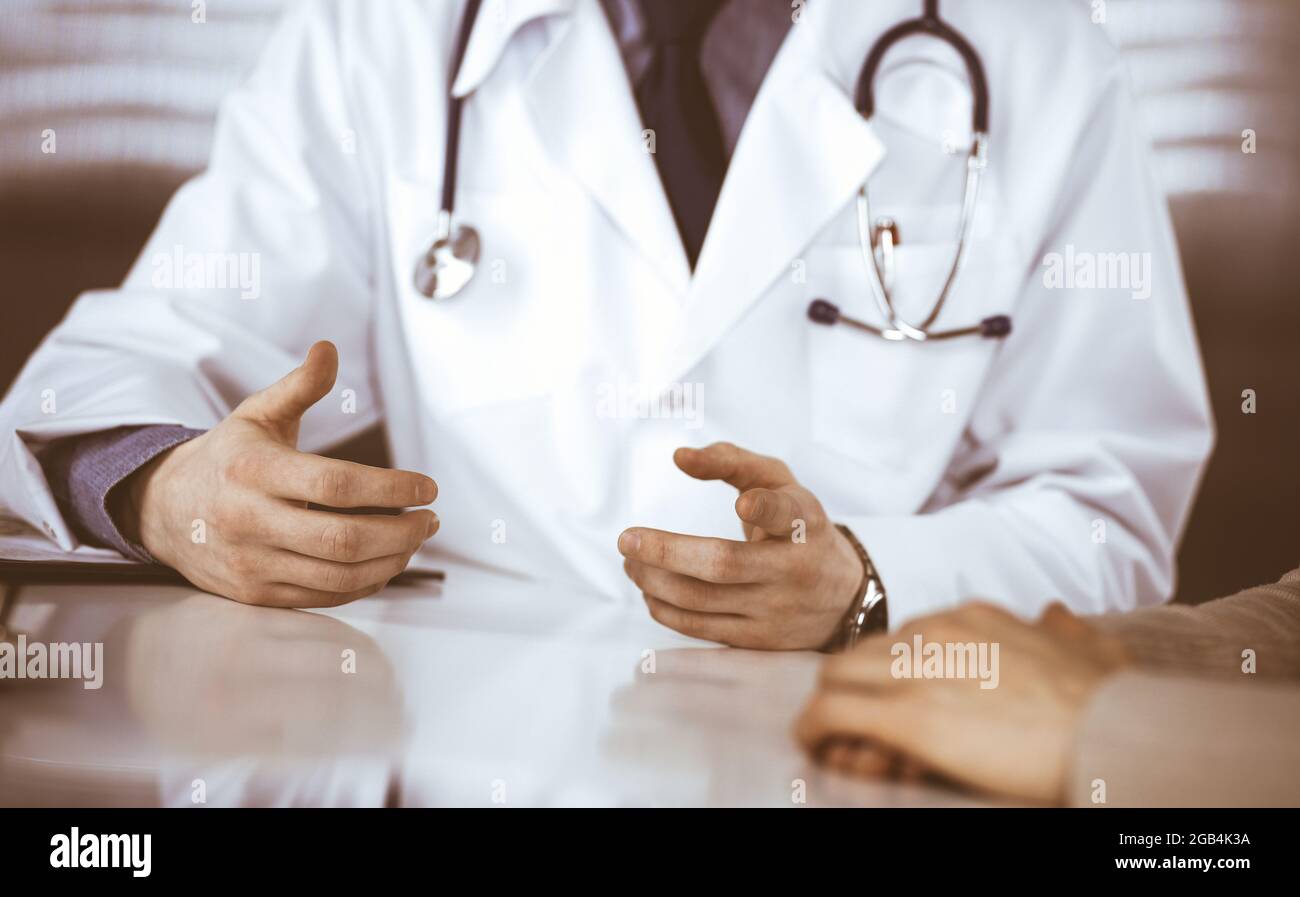 Unknown male doctor and patient woman discussing something while ...