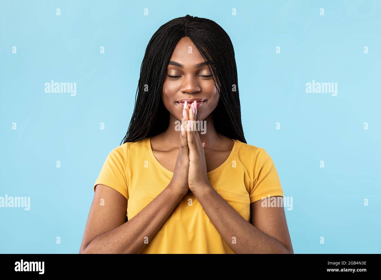 Happy African American Lady Praying With Eyes Closed, Blue Background ...