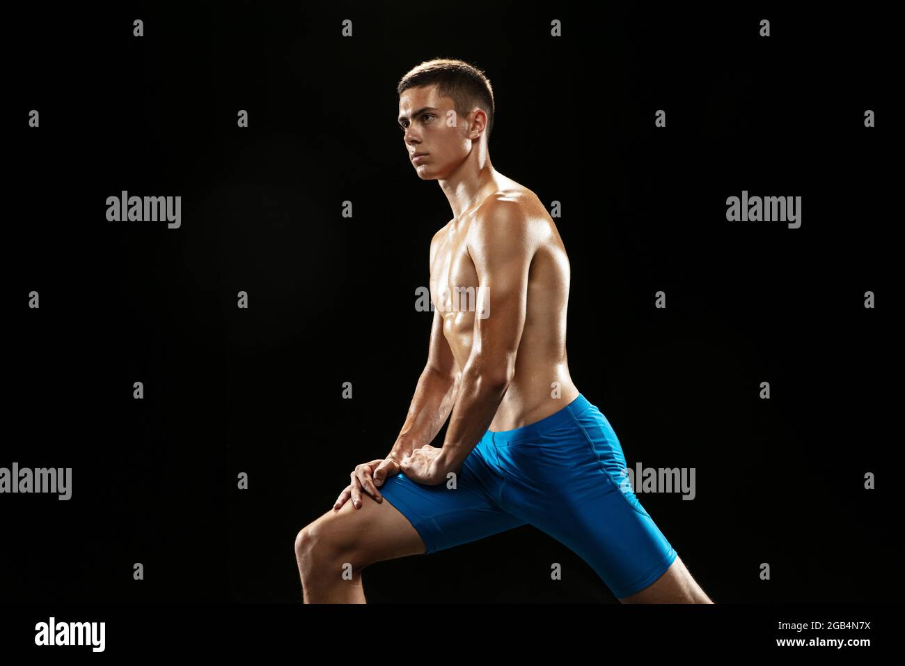 Warm-ups. Young male athlete, runner practicing isolated on black ...