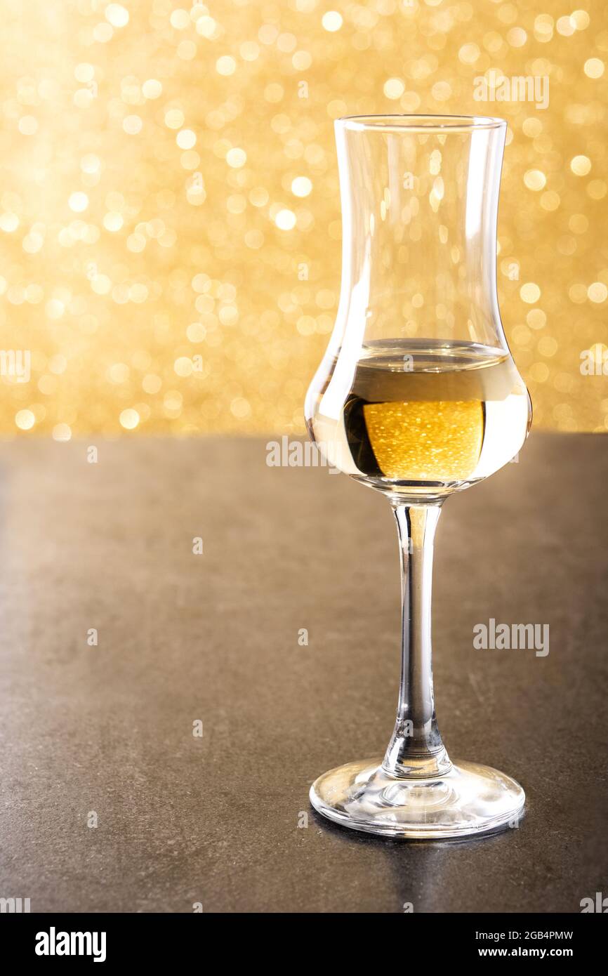 Italian golden grappa drink on black slate background Stock Photo - Alamy