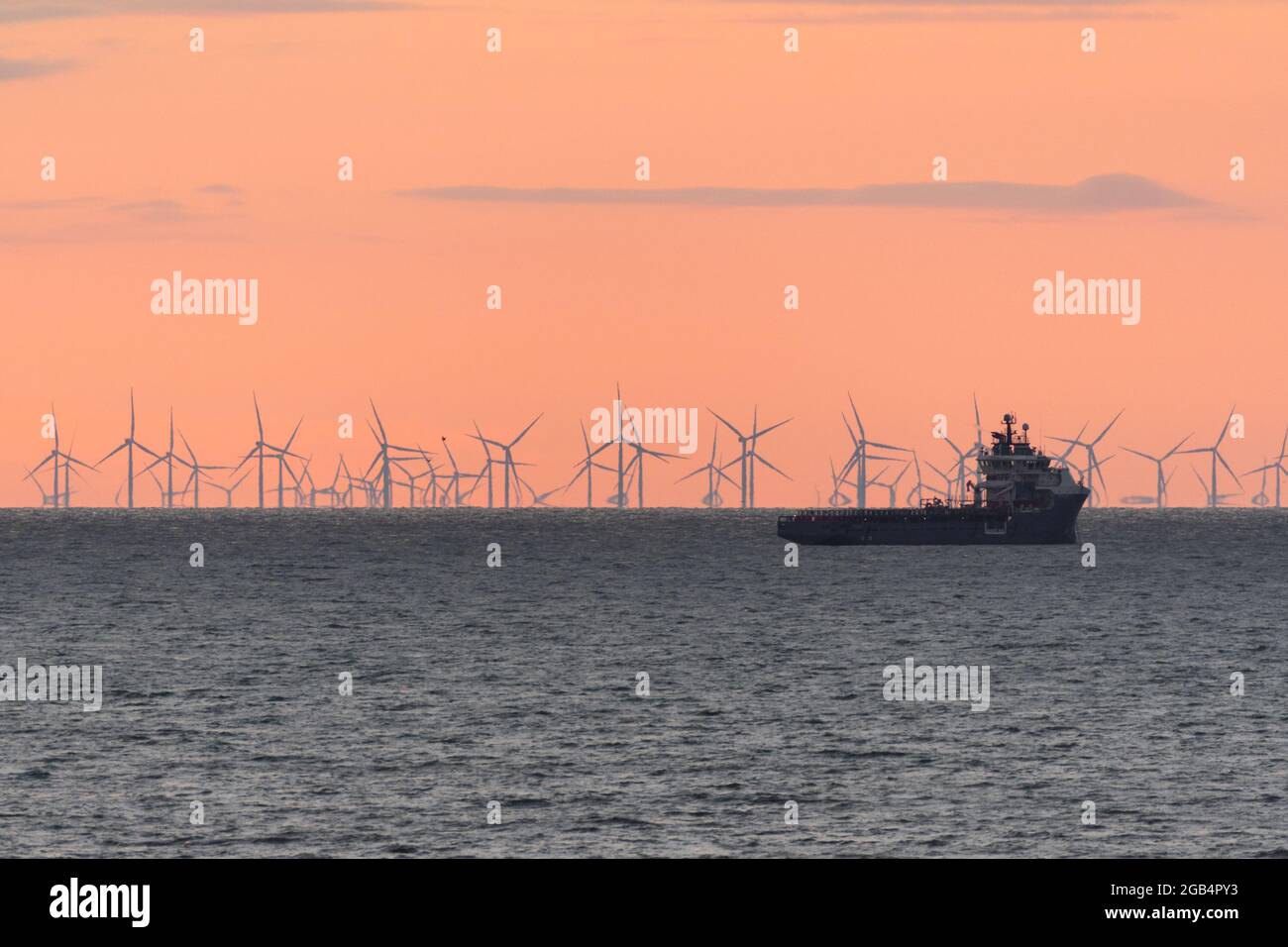 Wind farm in the Irish Sea at dusk. A mirage effect causes the turbines ...