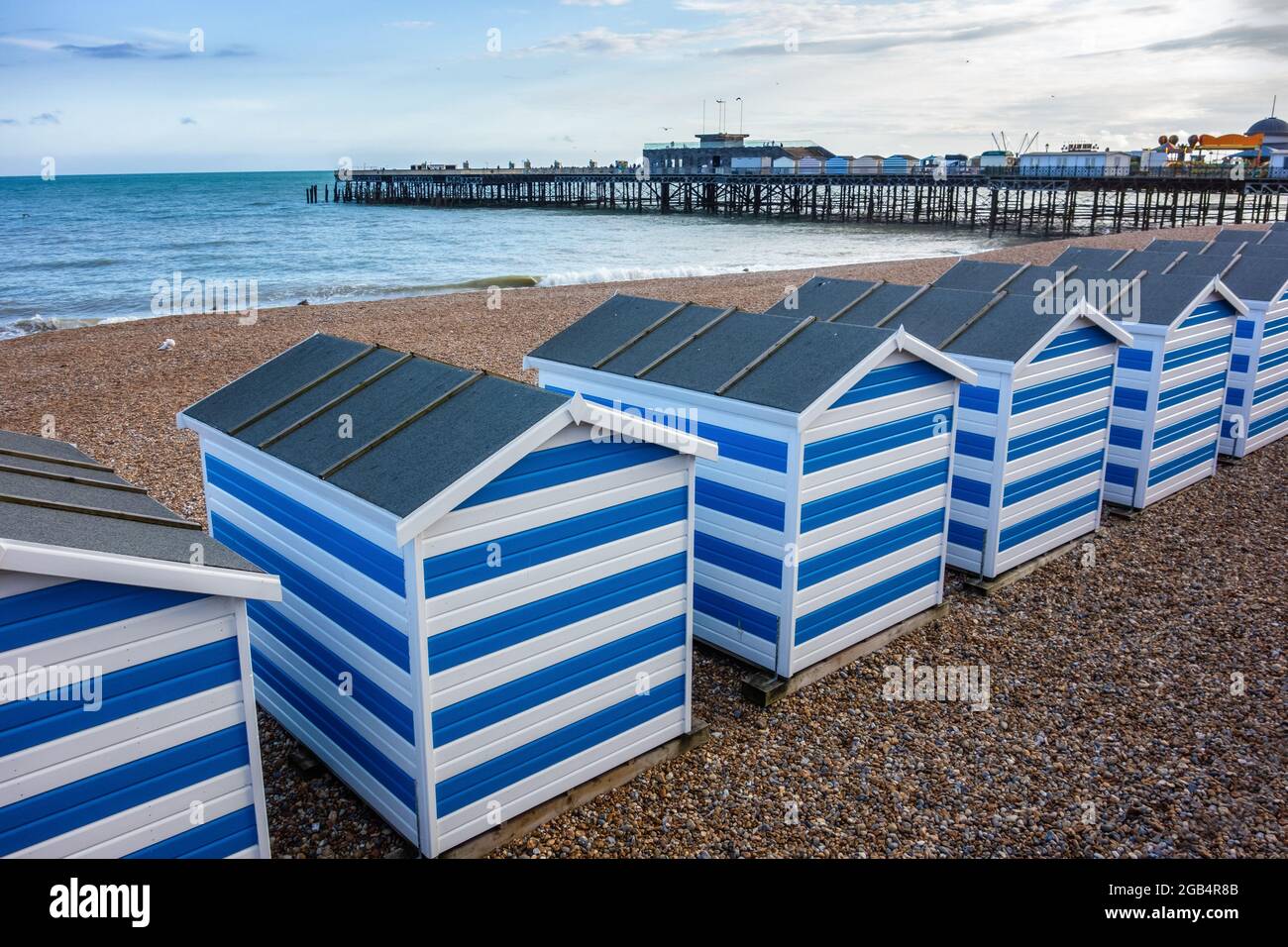 Blue and White beach huts with Hastings pier in the background Stock ...
