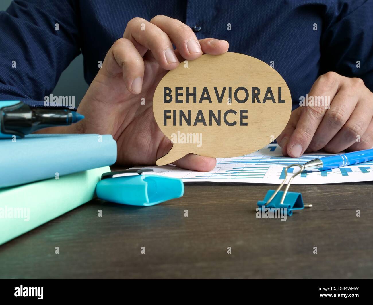 Man holds plate with behavioral finance words Stock Photo - Alamy