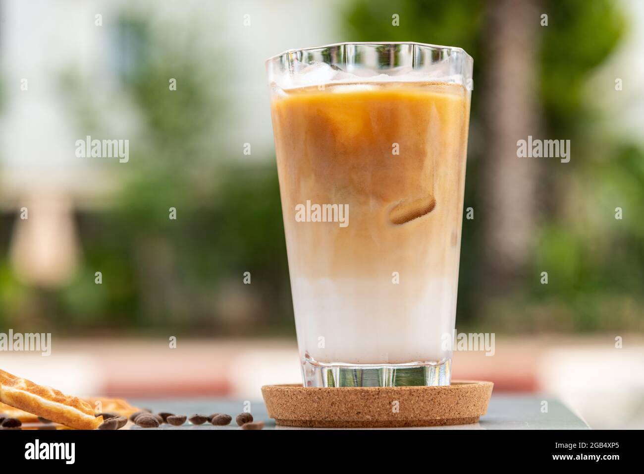 A cup of Iced Latte Coffee with ice cubes placed on a marble table in a ...